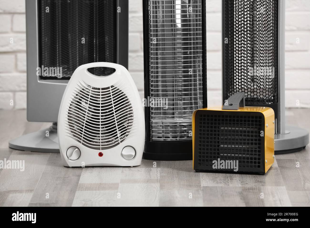 Different modern electric heaters on floor in room Stock Photo - Alamy