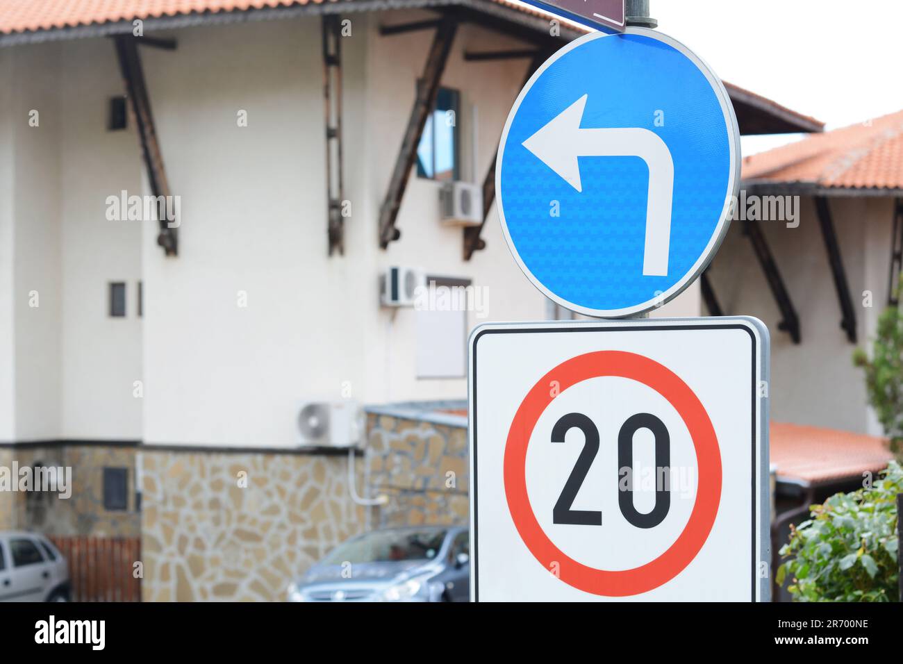 Post with traffic signs Speed Limit and Turn Left Ahead outdoors. Space ...