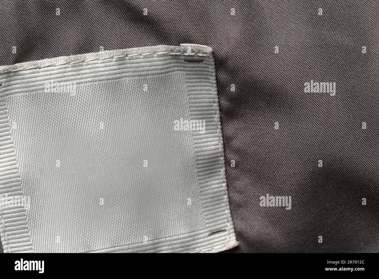 Clothing label on black garment, top view Stock Photo - Alamy