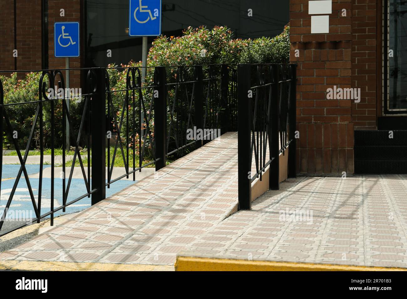 Tiled ramp with black metal railings outdoors Stock Photo - Alamy