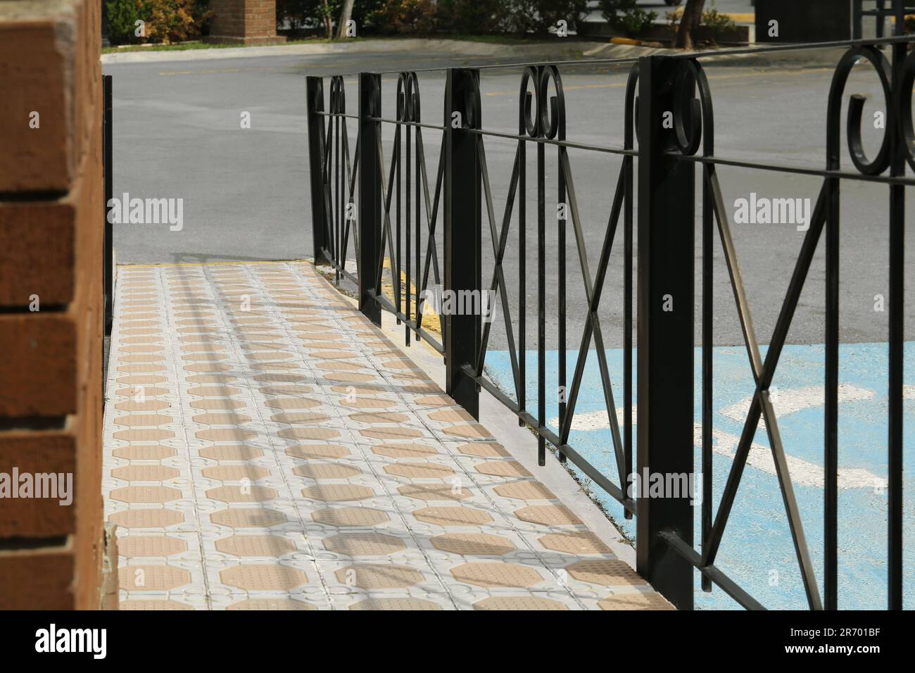 Tiled ramp with black metal railings outdoors Stock Photo - Alamy