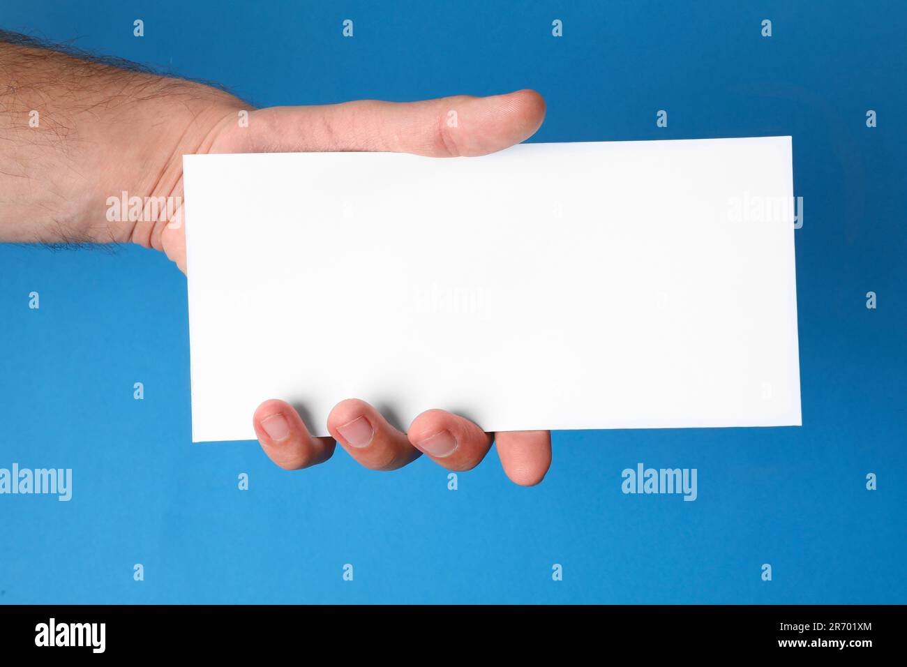 Man holding flyer on blue background, closeup. Mockup for design Stock ...