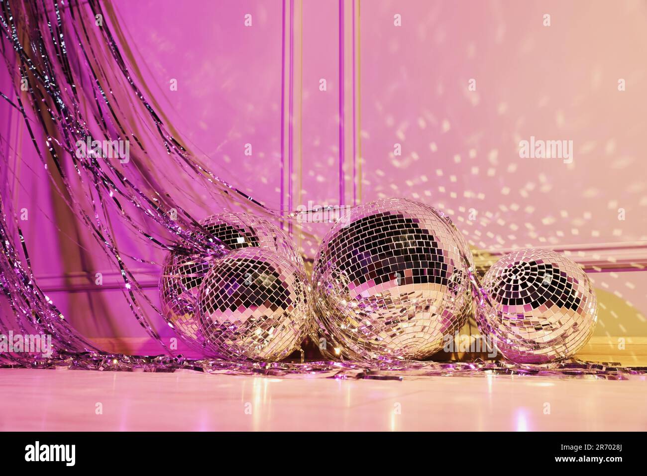 Shiny disco balls and foil fringe curtain indoors, color toned Stock ...