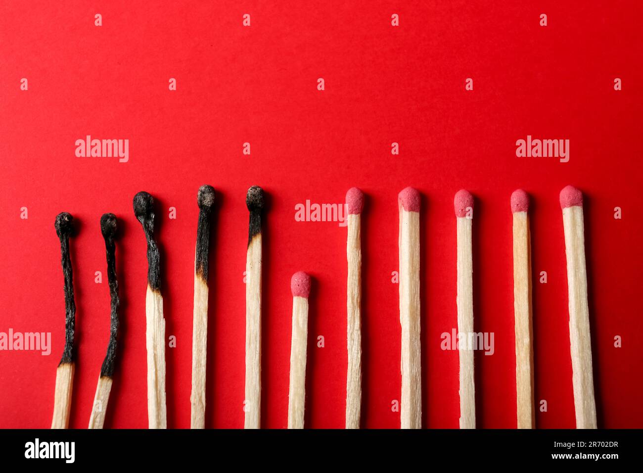 Burnt and whole matches on red background, flat lay. Stop destruction ...