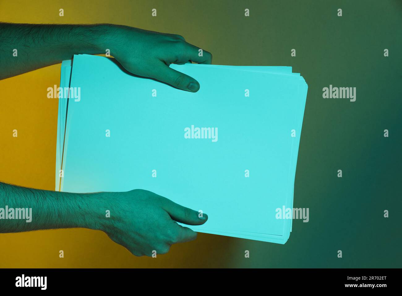 Man holding sheets of paper on dark background, closeup and space for ...