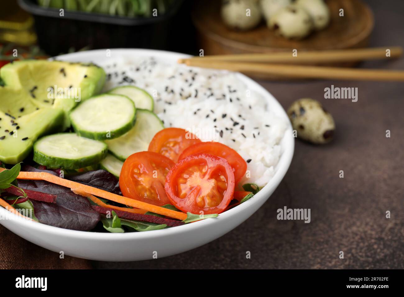 Delicious poke bowl with vegetables, avocado and mesclun on textured ...
