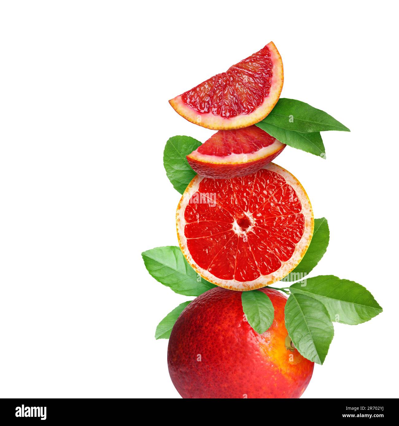 Stacked cut and whole red oranges with green leaves on white background ...