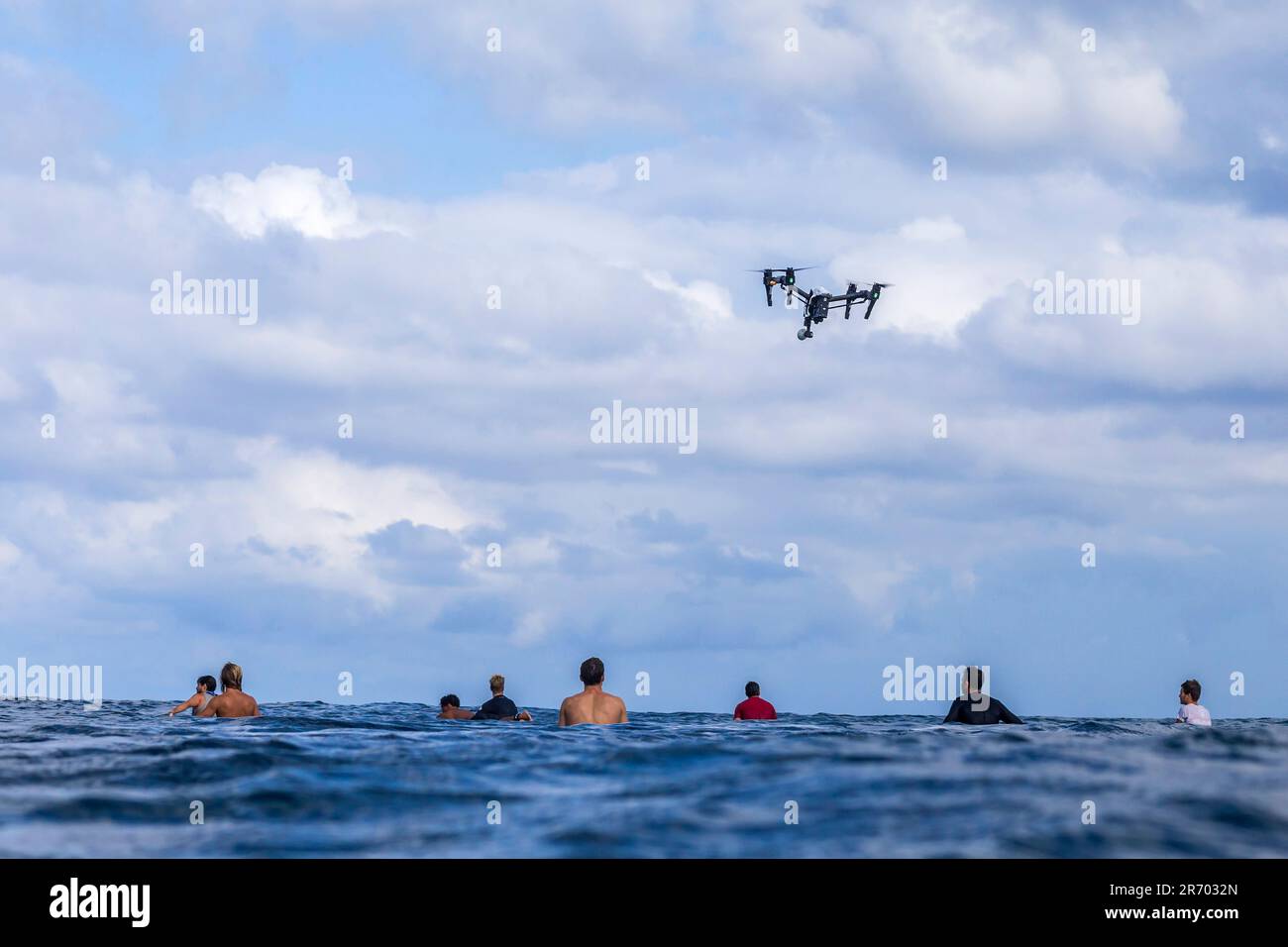 Group Of Surfers In The Water Looking At Drone Flying Over Sea Stock ...