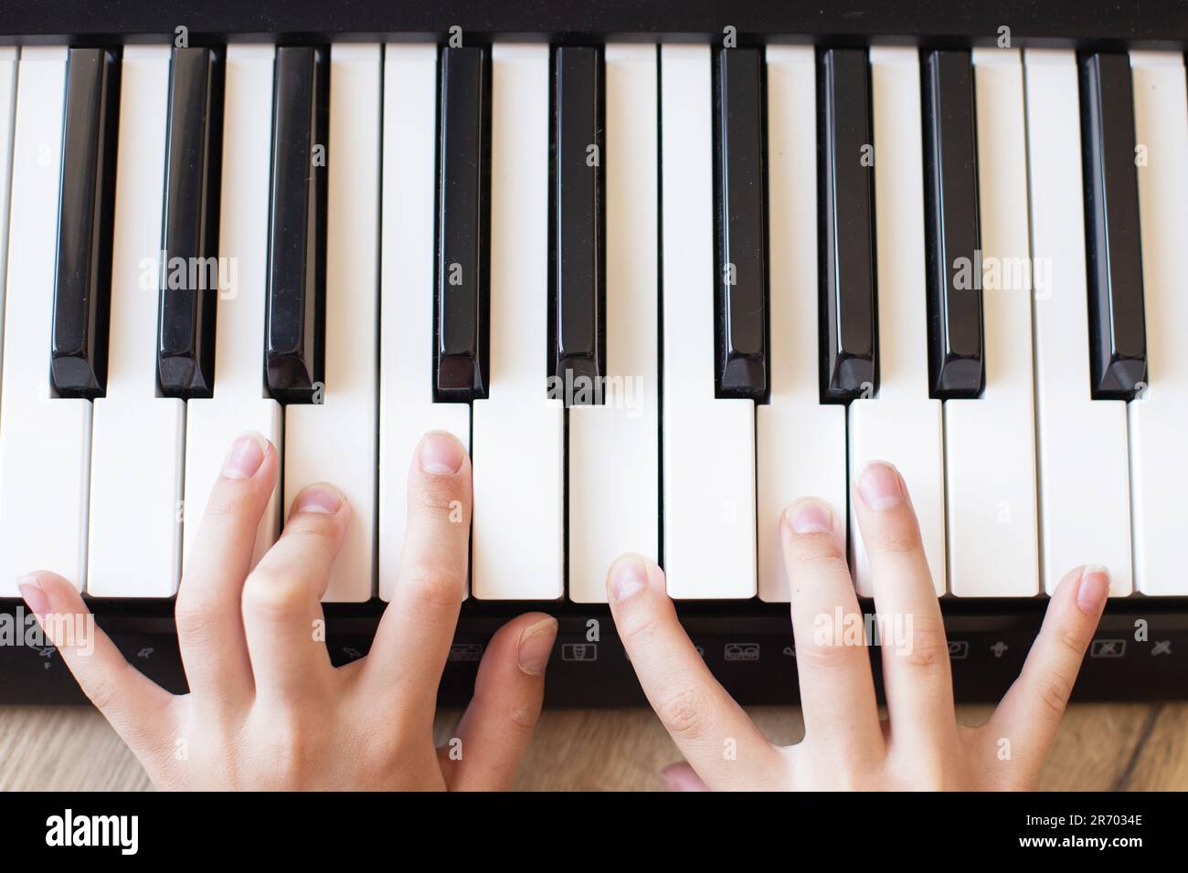 Child hands is playing, learning and practicing the piano. Piano chords ...