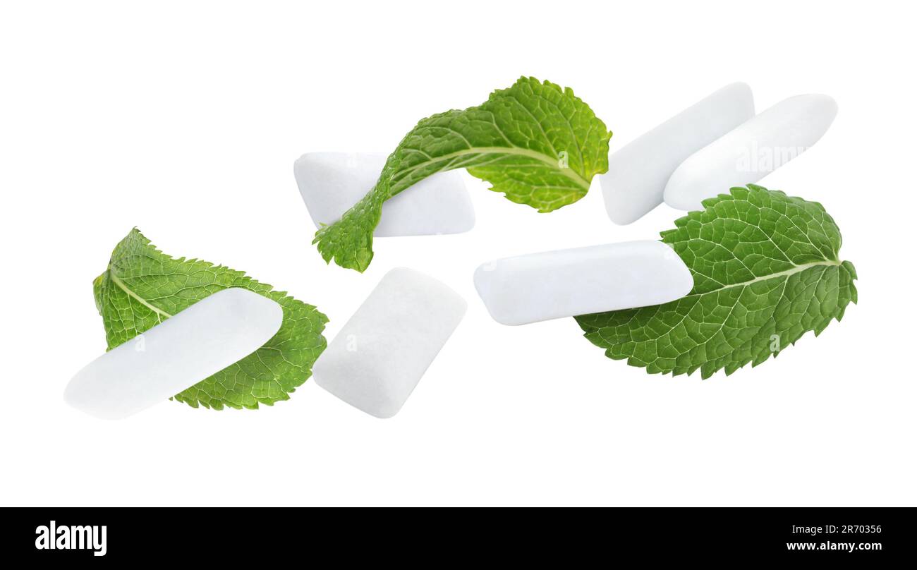 Fresh mint leaves and chewing gum pads falling on white background ...