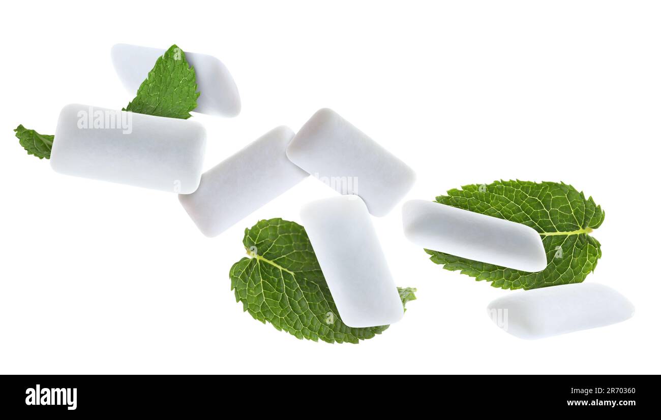 Fresh mint leaves and chewing gum pads falling on white background ...