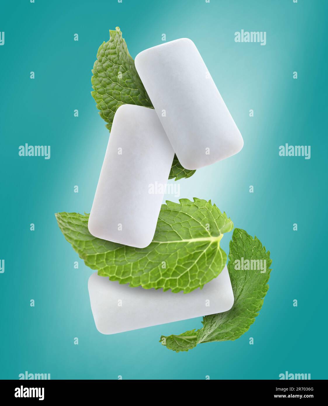 Fresh mint leaves and chewing gum pads falling on turquoise background ...