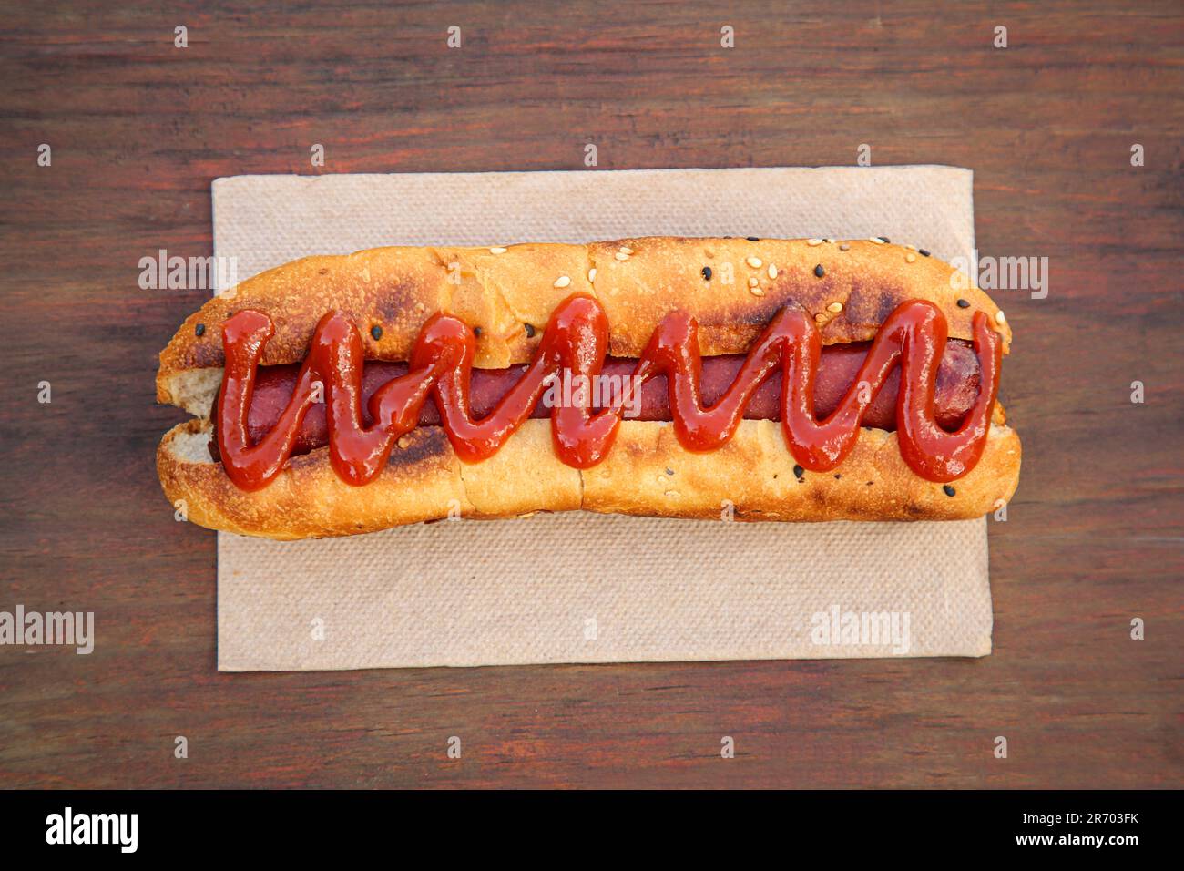 Fresh tasty hot dog with ketchup on wooden table, top view Stock Photo ...