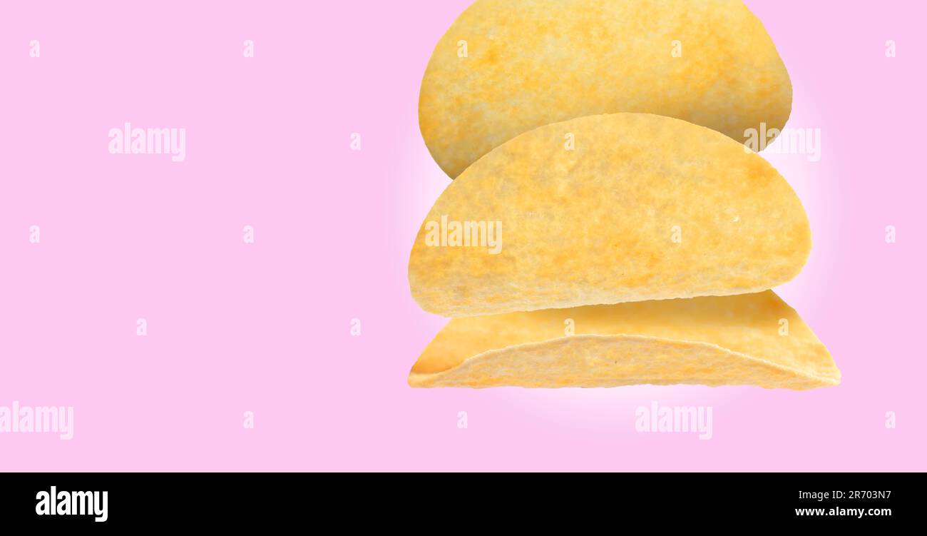 Stack of tasty potato chips on light violet background, space for text ...