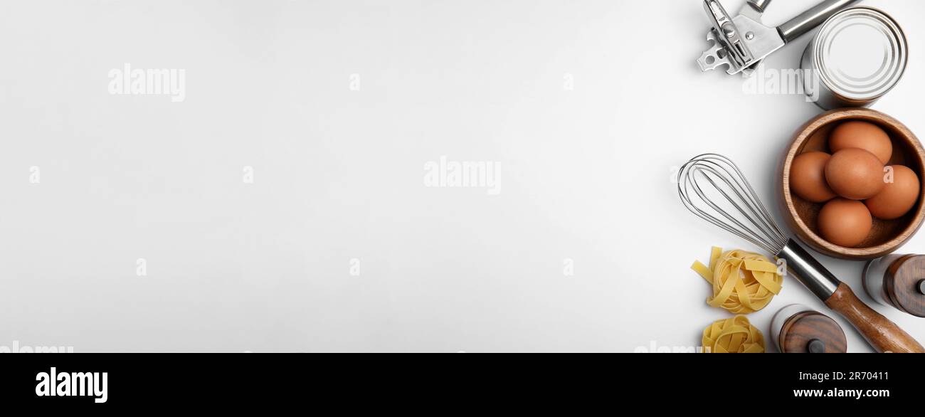 Cooking utensils and ingredients on white background, flat lay with ...