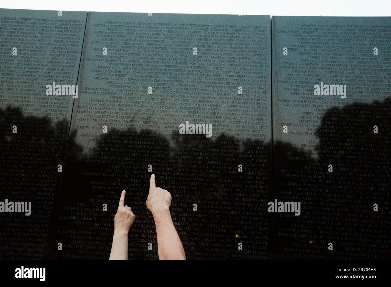 People touch and point at names on the Vietnam Veterans Memorial Wall ...