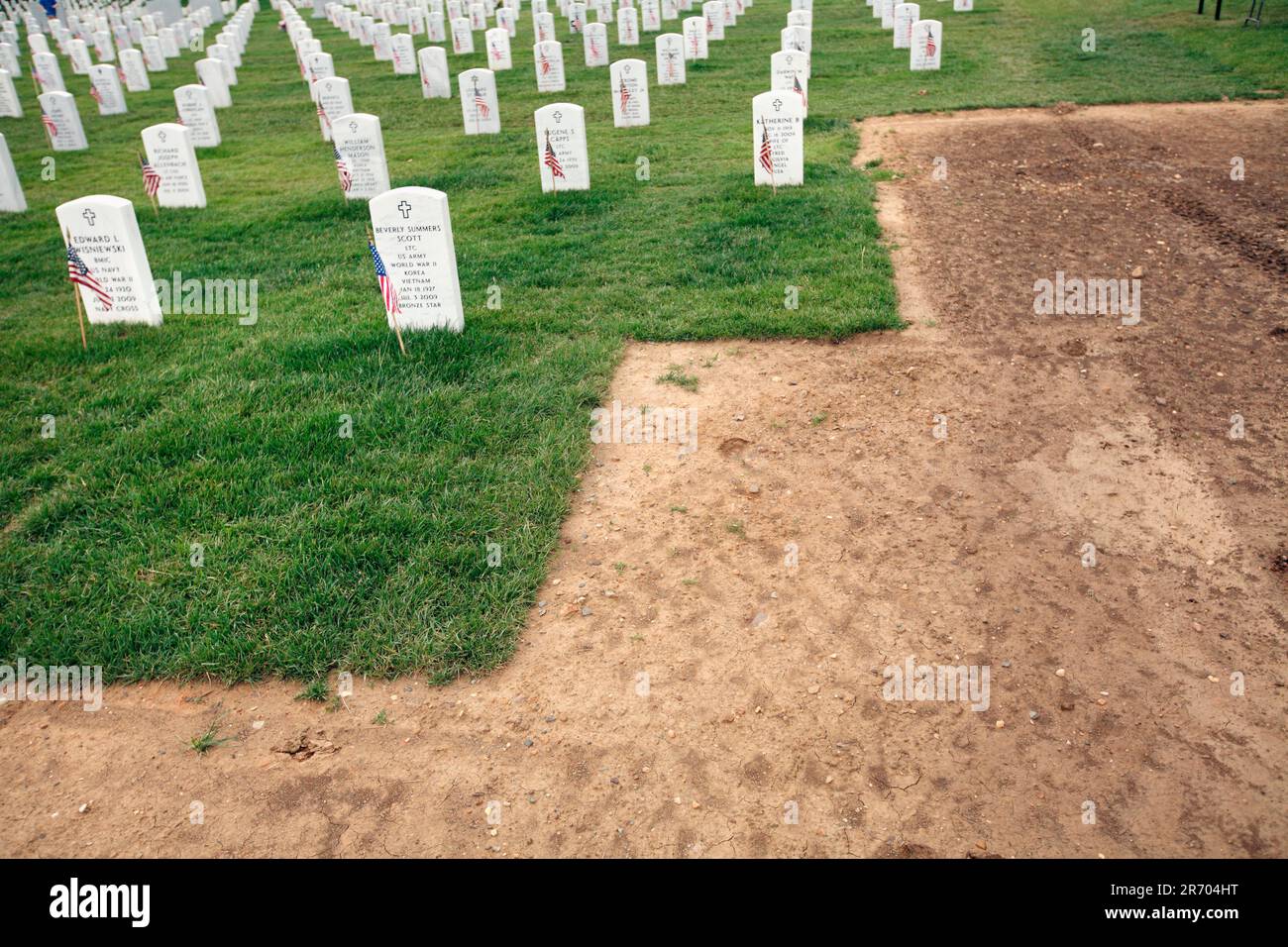 Grass and gravestones border mud from newly dug graves at Section 60 in ...