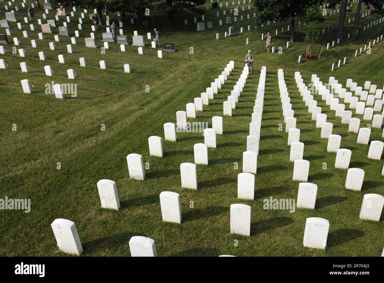 Soldiers place flags on graves at Arlington National Cemetery Stock ...