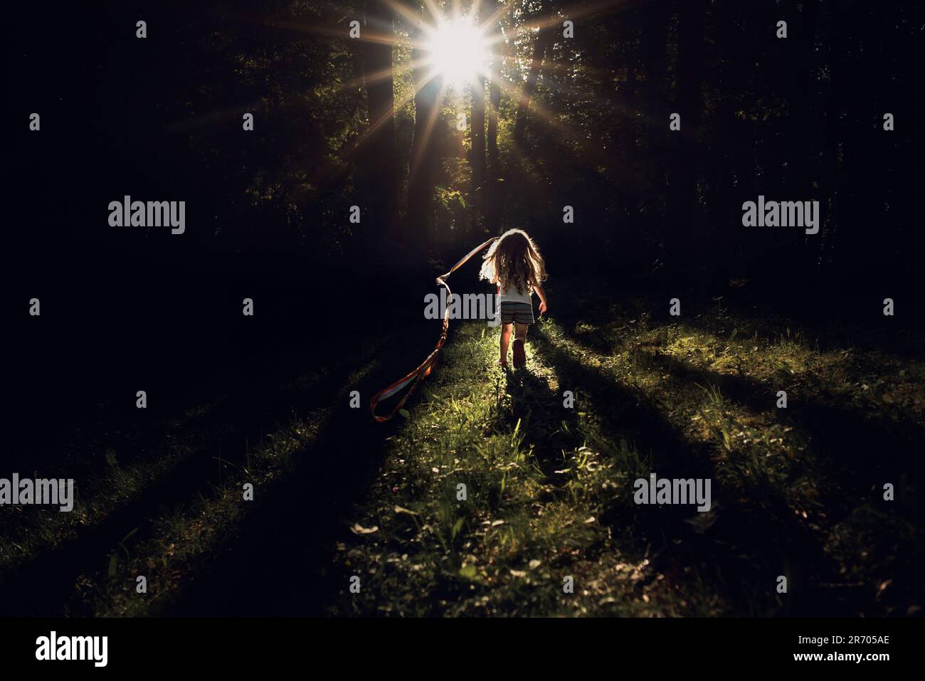 Little girl running in green field with streamer Stock Photo - Alamy