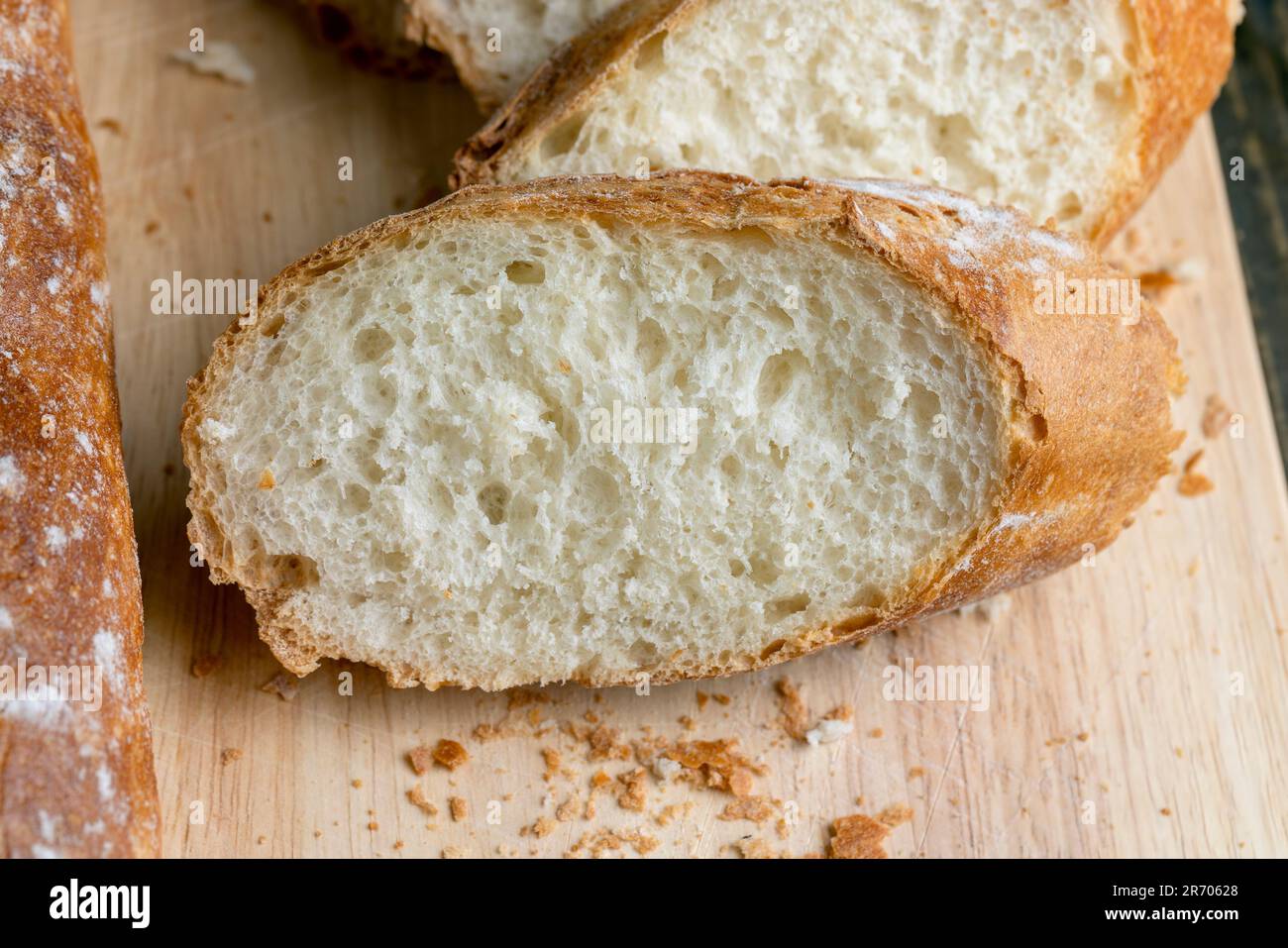 Cut white bread into pieces, traditional white baguette with porous ...