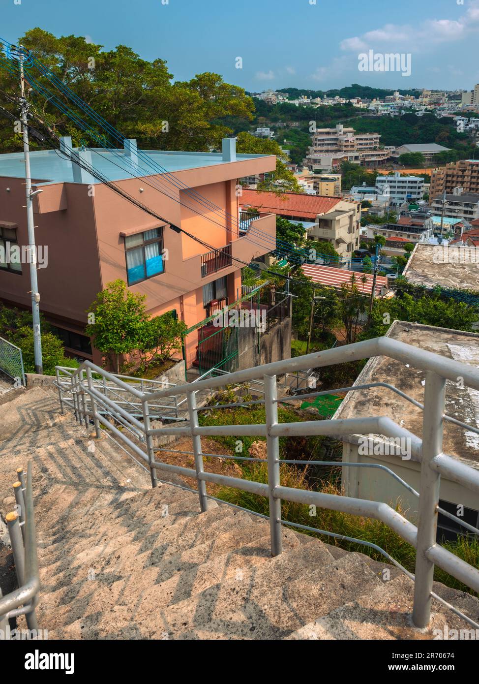 A modern metal railing with a set of stairs leading between houses in ...