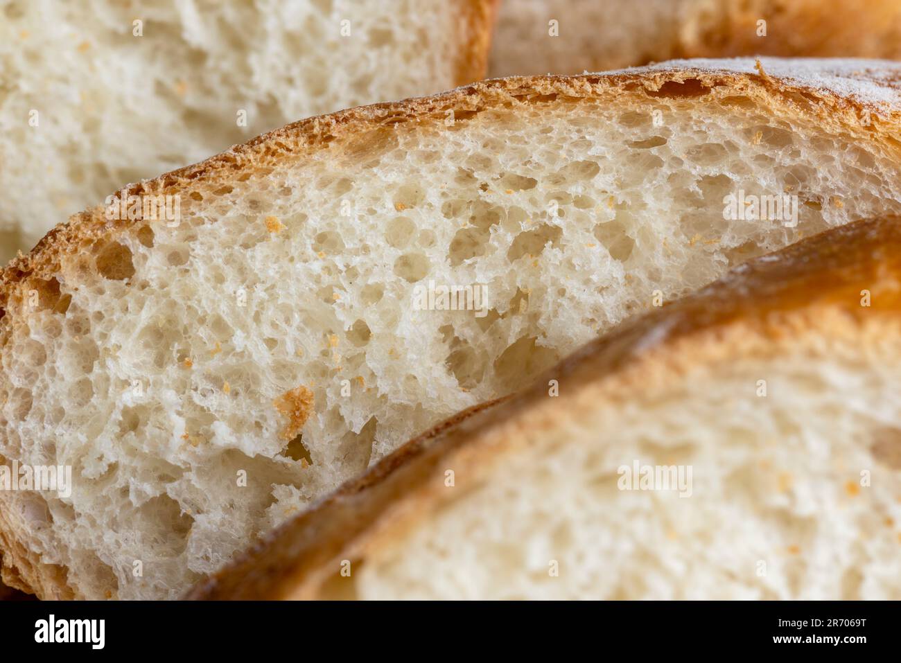 Cut white bread into pieces, traditional white baguette with porous ...