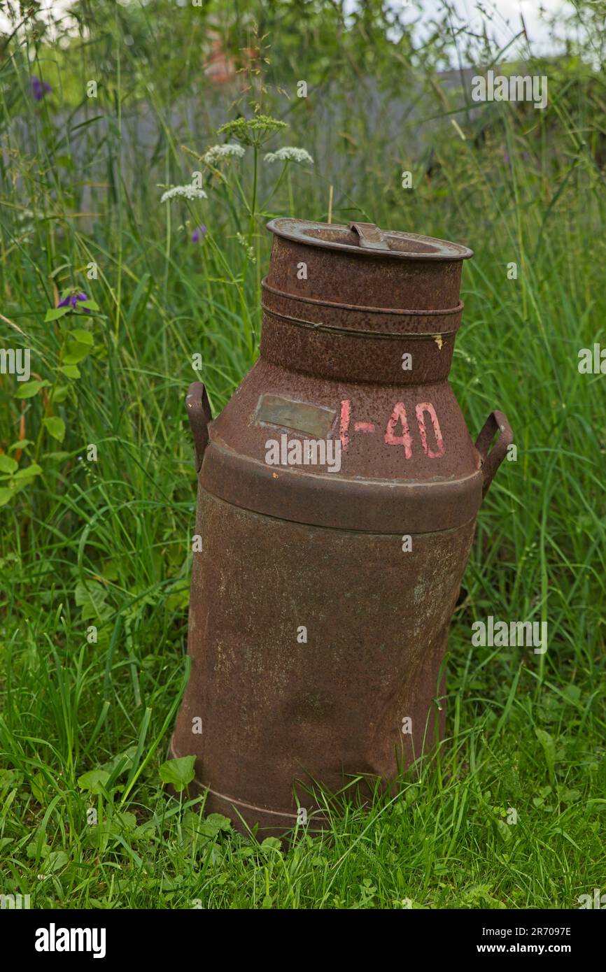 Old and rusty milk jug outside in garden Stock Photo - Alamy
