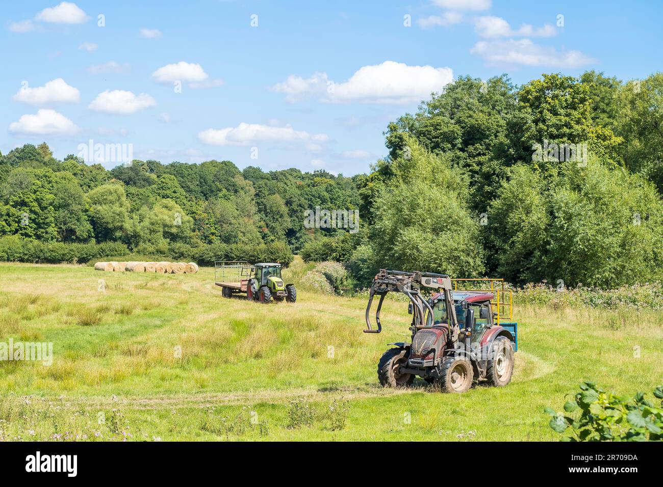 Farmer's tractors driving around a grassy field after dropping off ...