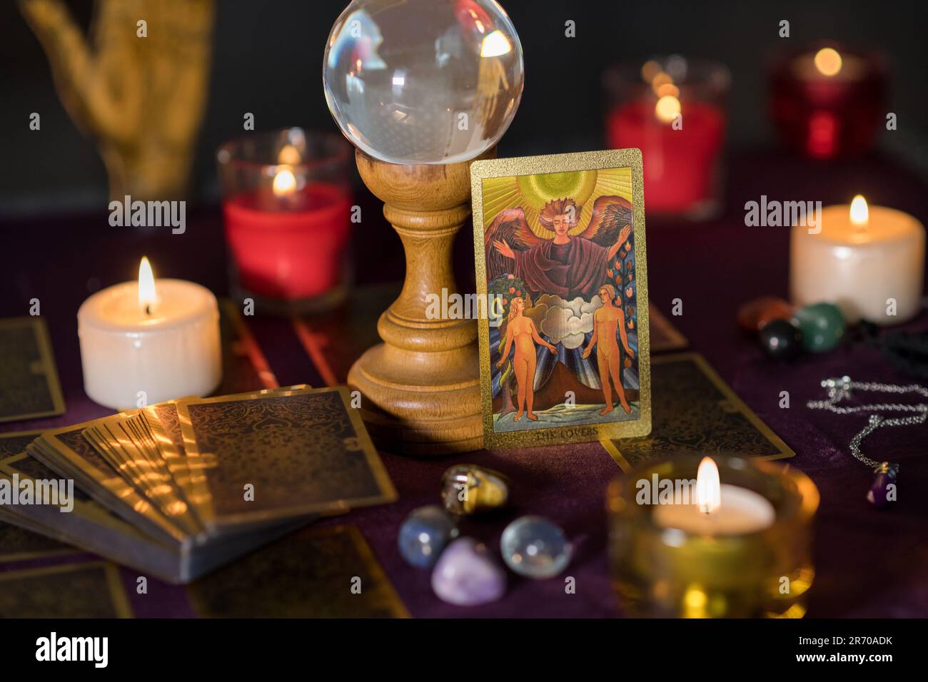 Magic ball and burning candles with lovers tarot card placed on fortune ...