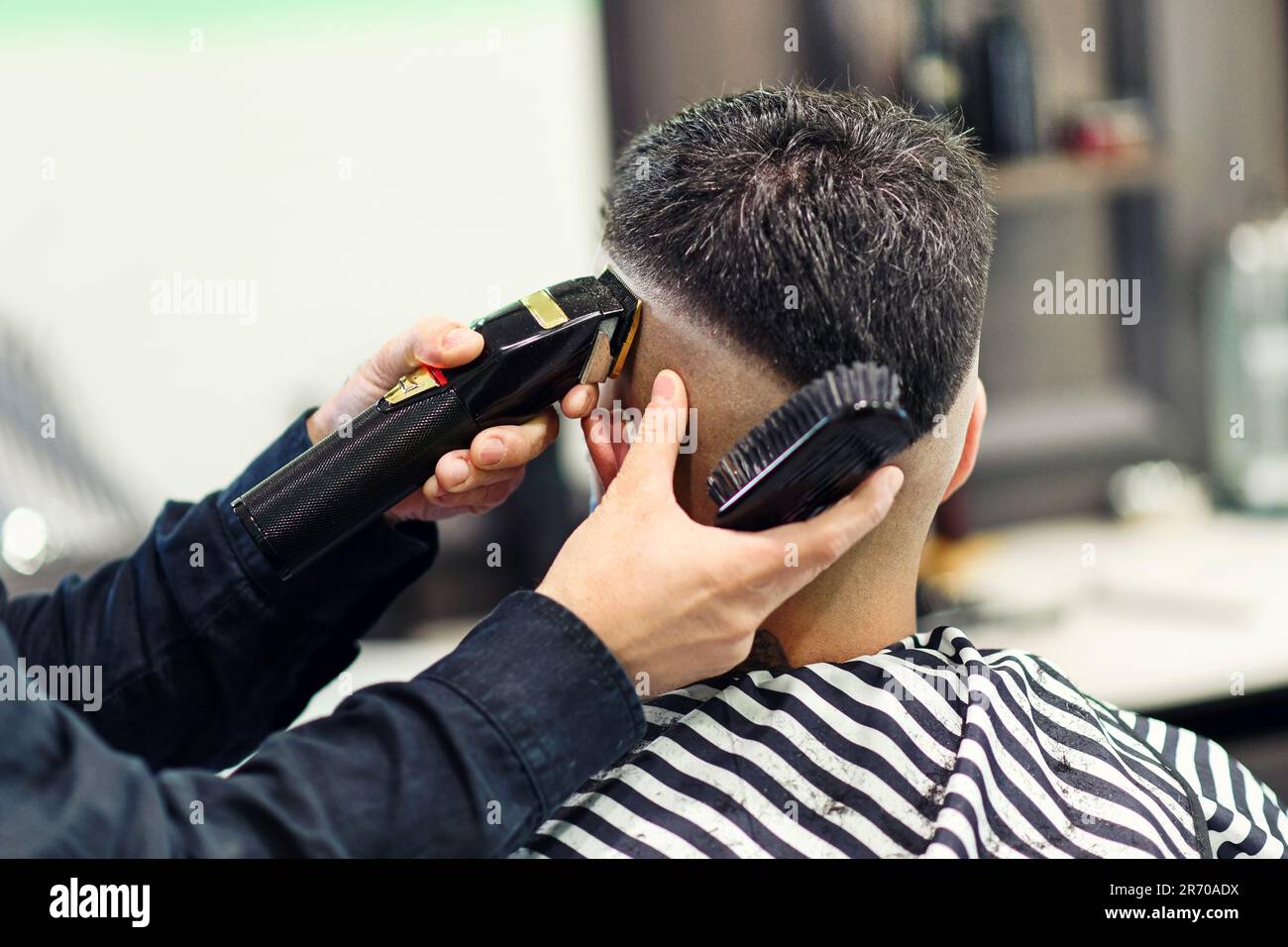 Barber trimming anonymous guy while working in professional salon Stock ...