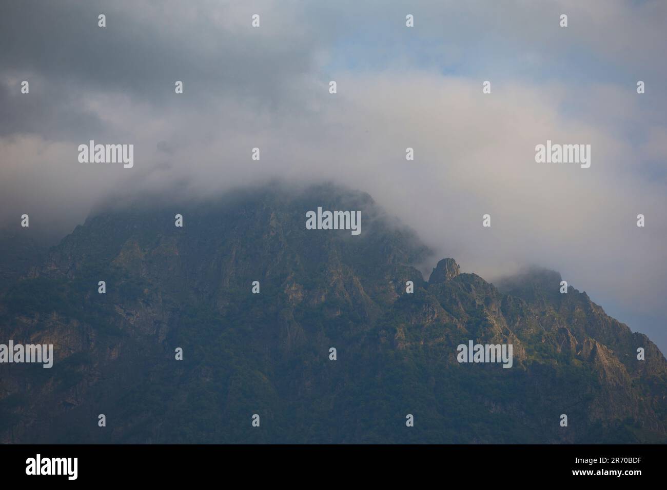 Dark atmospheric surreal landscape with a dark rocky mountain peak in ...