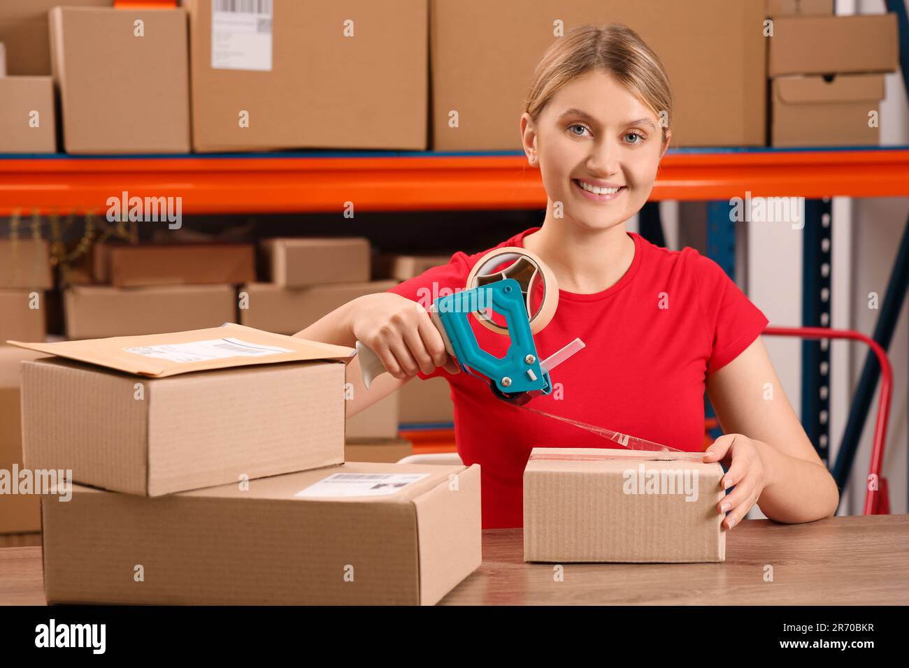 Post office worker packing parcel at counter indoors Stock Photo - Alamy