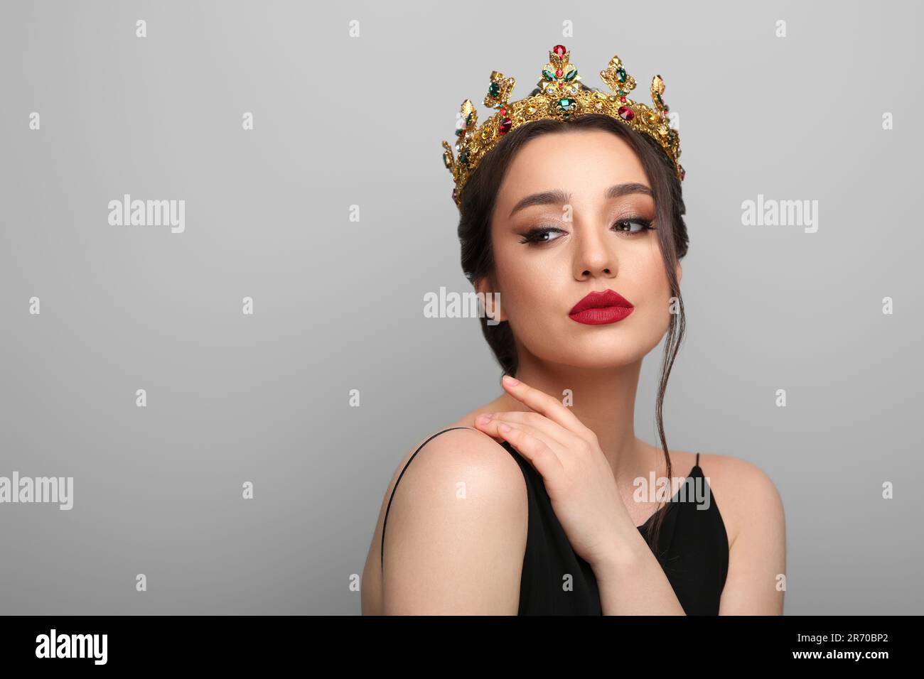 Beautiful young woman wearing luxurious crown on light grey background, space for text Stock ...