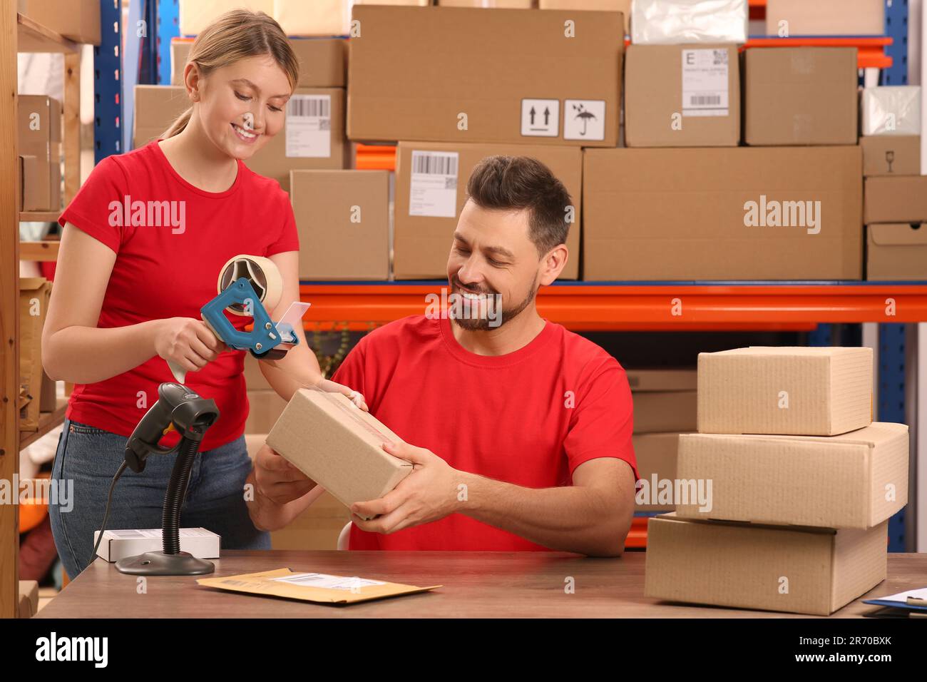 Post office workers packing parcel at counter indoors Stock Photo - Alamy