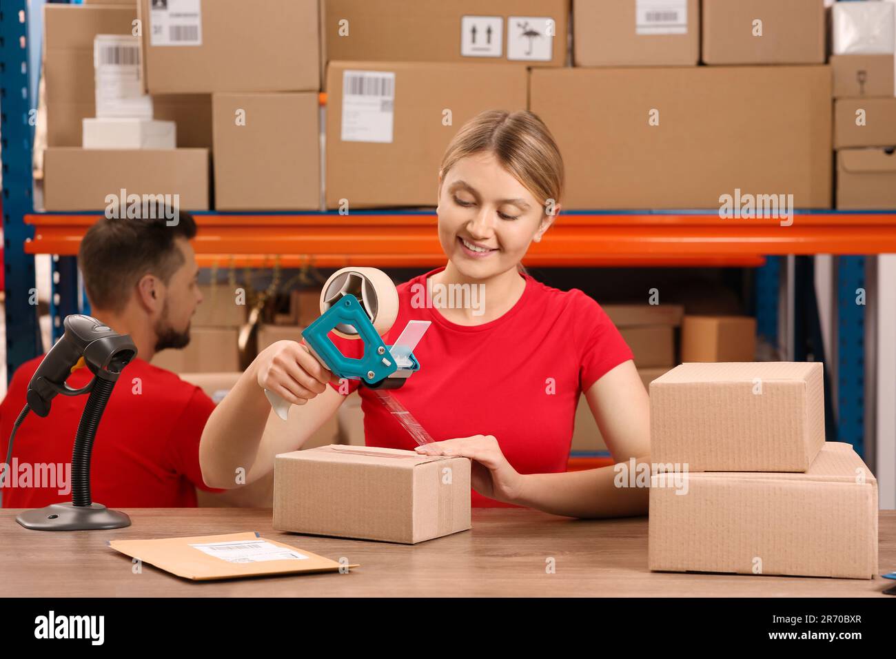 Post office worker packing parcel at counter indoors Stock Photo - Alamy