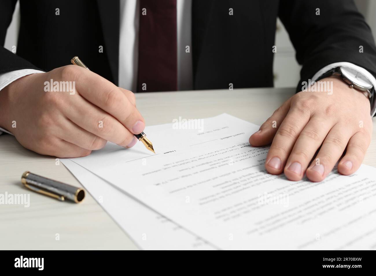 Notary signing document at wooden table, closeup Stock Photo - Alamy
