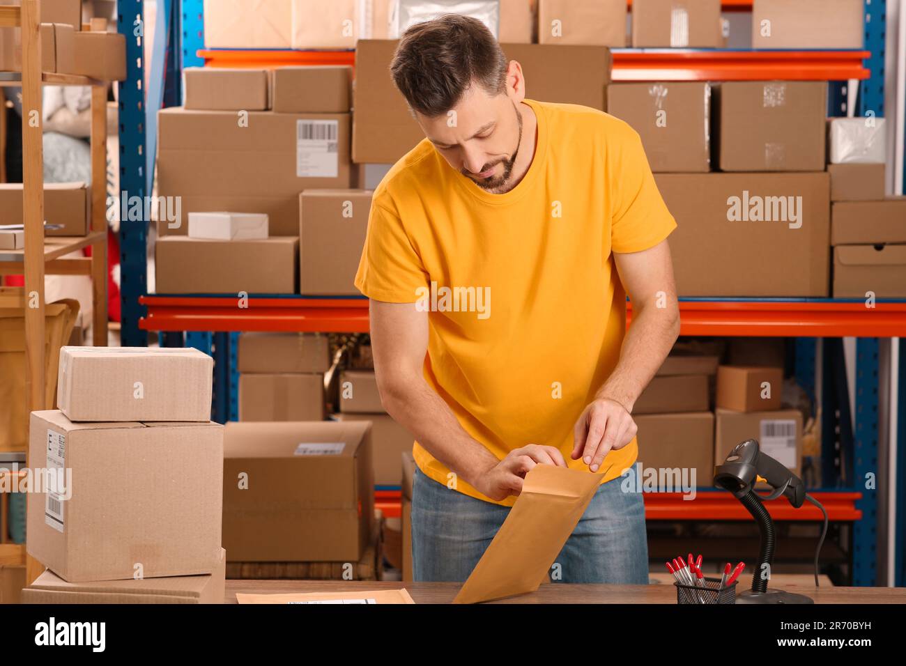 Post office worker with adhesive paper bag at counter indoors Stock ...