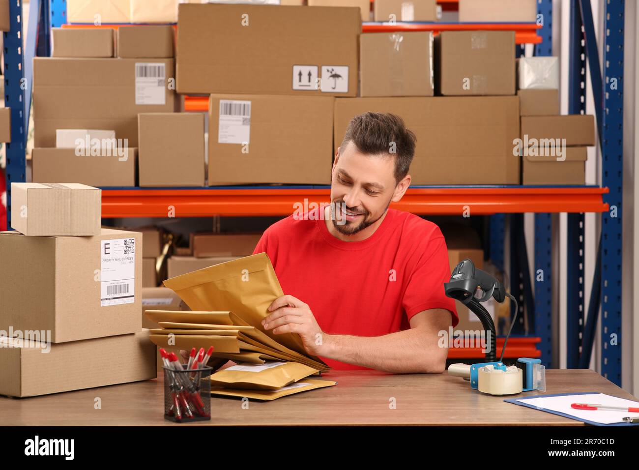 Post office worker with adhesive paper bags at counter indoors Stock ...