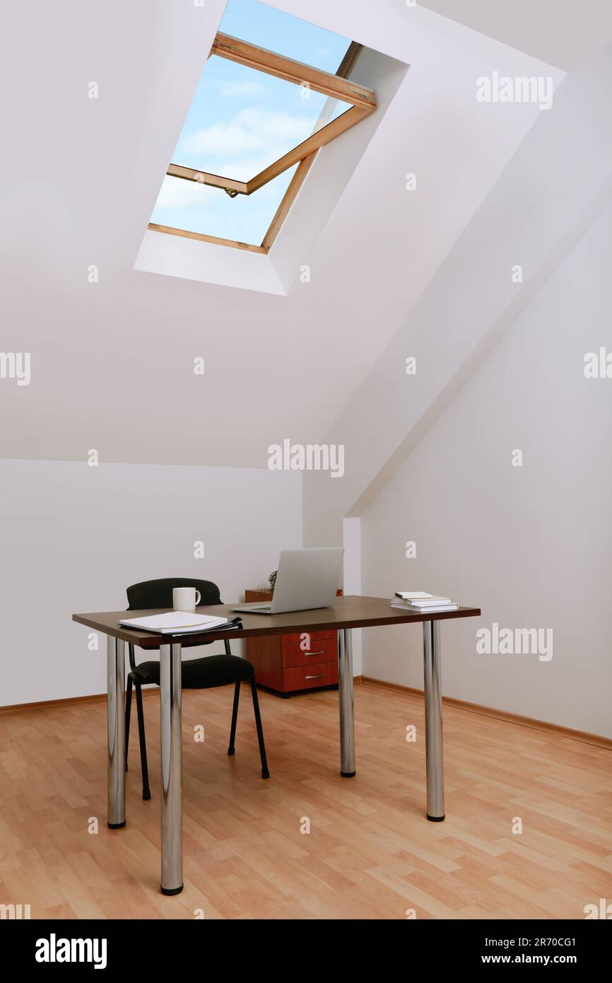 Stylish workplace with laptop and documents in attic room. Interior ...