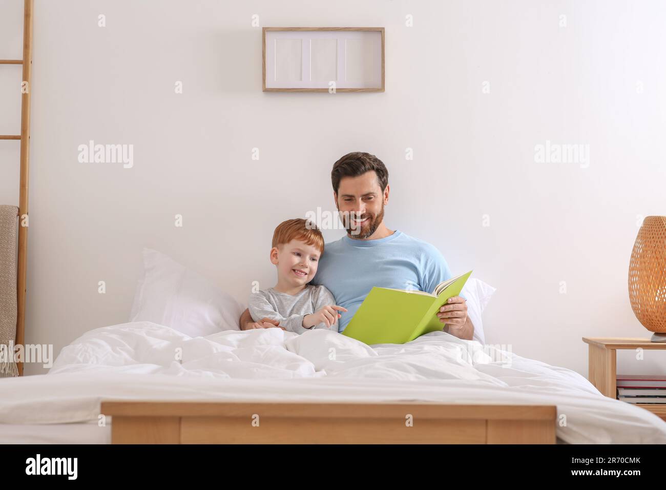 Father reading book with his child on bed at home Stock Photo - Alamy
