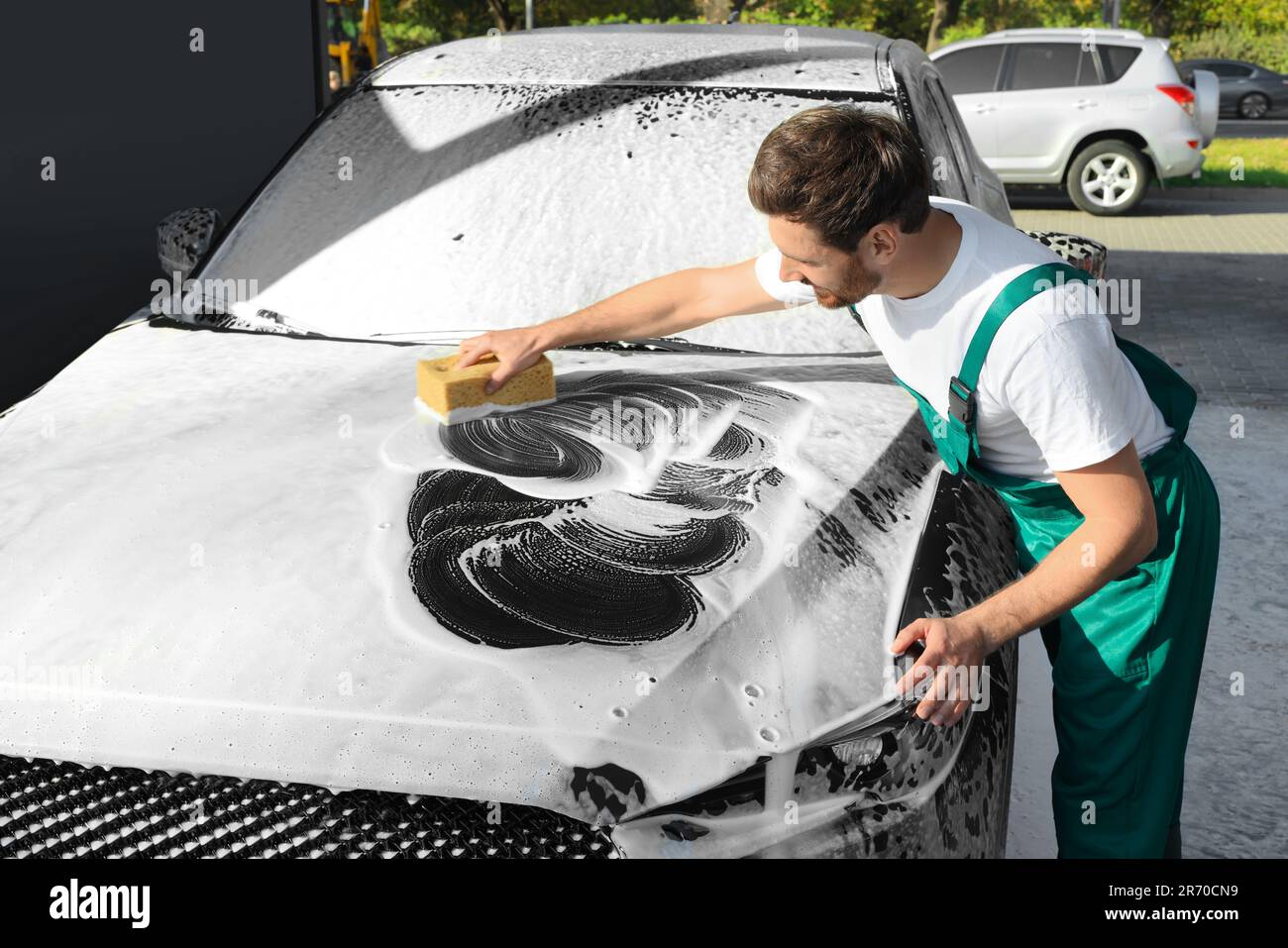 Worker washing auto with sponge at outdoor car wash Stock Photo - Alamy