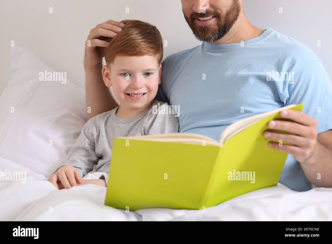 Father reading book with his child on bed at home Stock Photo - Alamy