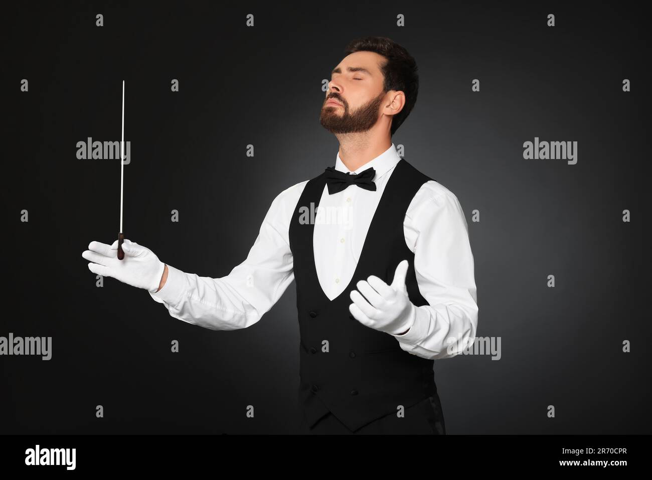 Professional conductor with baton on black background Stock Photo - Alamy