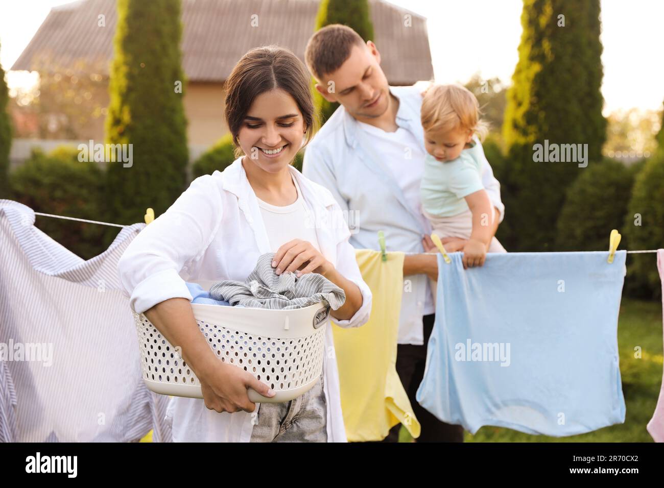 Happy family near washing line with drying clothes in backyard Stock ...