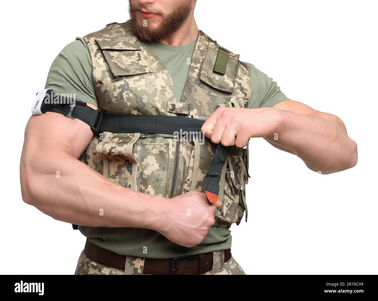 Soldier in military uniform applying medical tourniquet on arm against ...
