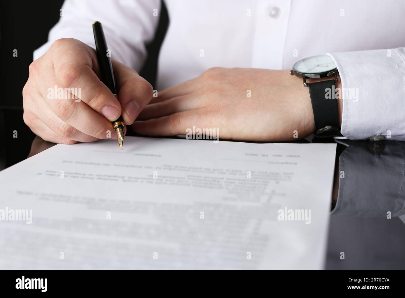 Notary signing document at black table, closeup Stock Photo - Alamy