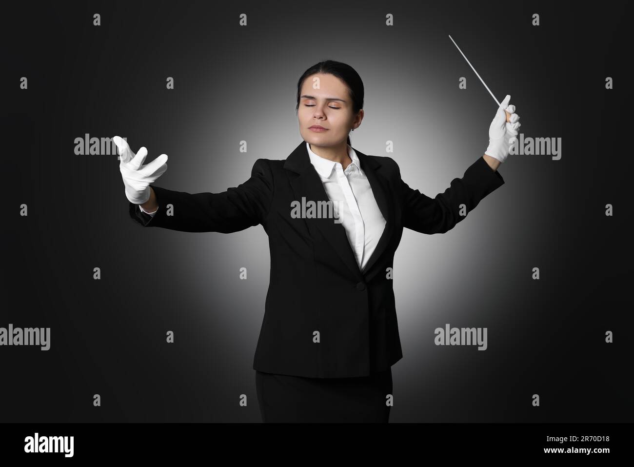 Professional conductor with baton on black background Stock Photo - Alamy