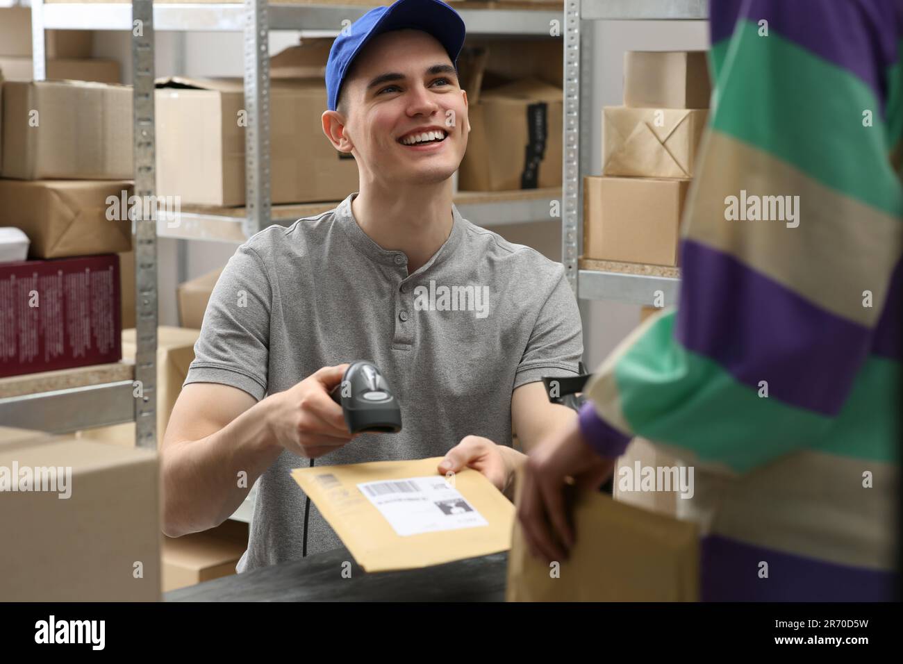 Woman and post office worker with scanner reading parcel barcode at ...