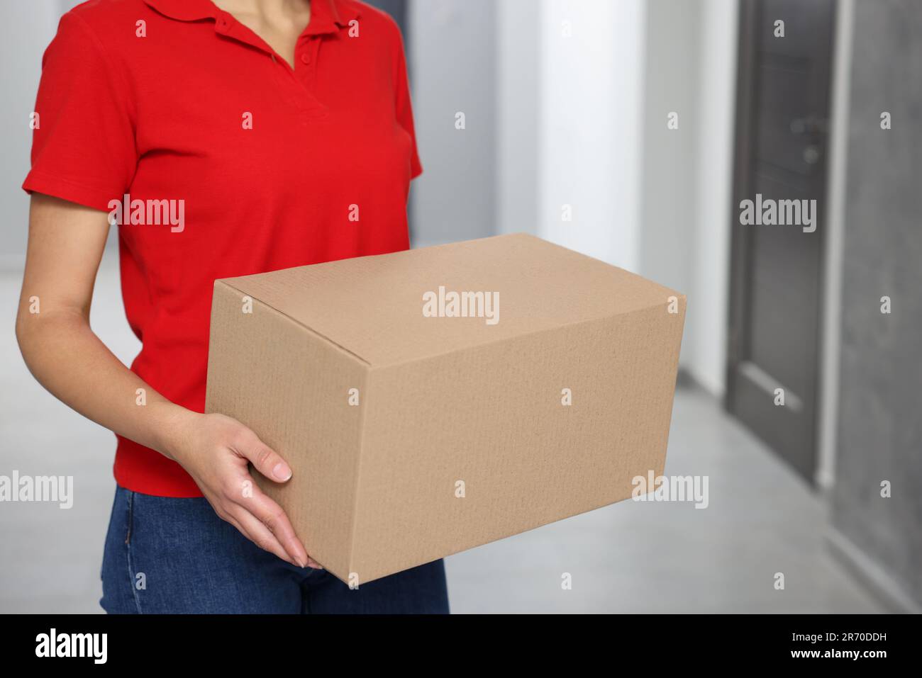 Courier with cardboard boxes in hallway, closeup Stock Photo - Alamy