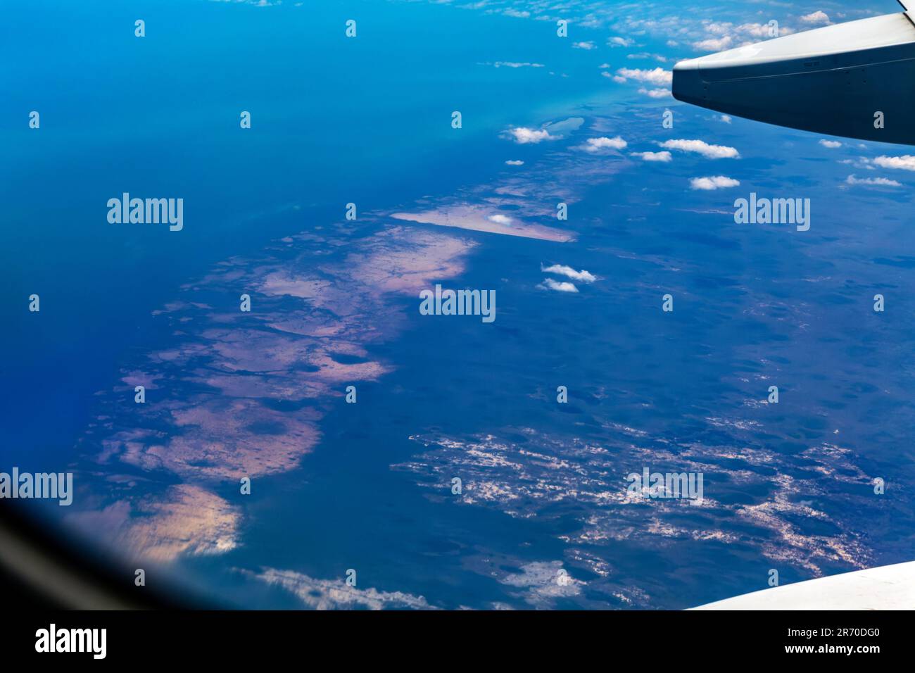 Oblique angle aerial view through plane window over Gulf of Mexico ...
